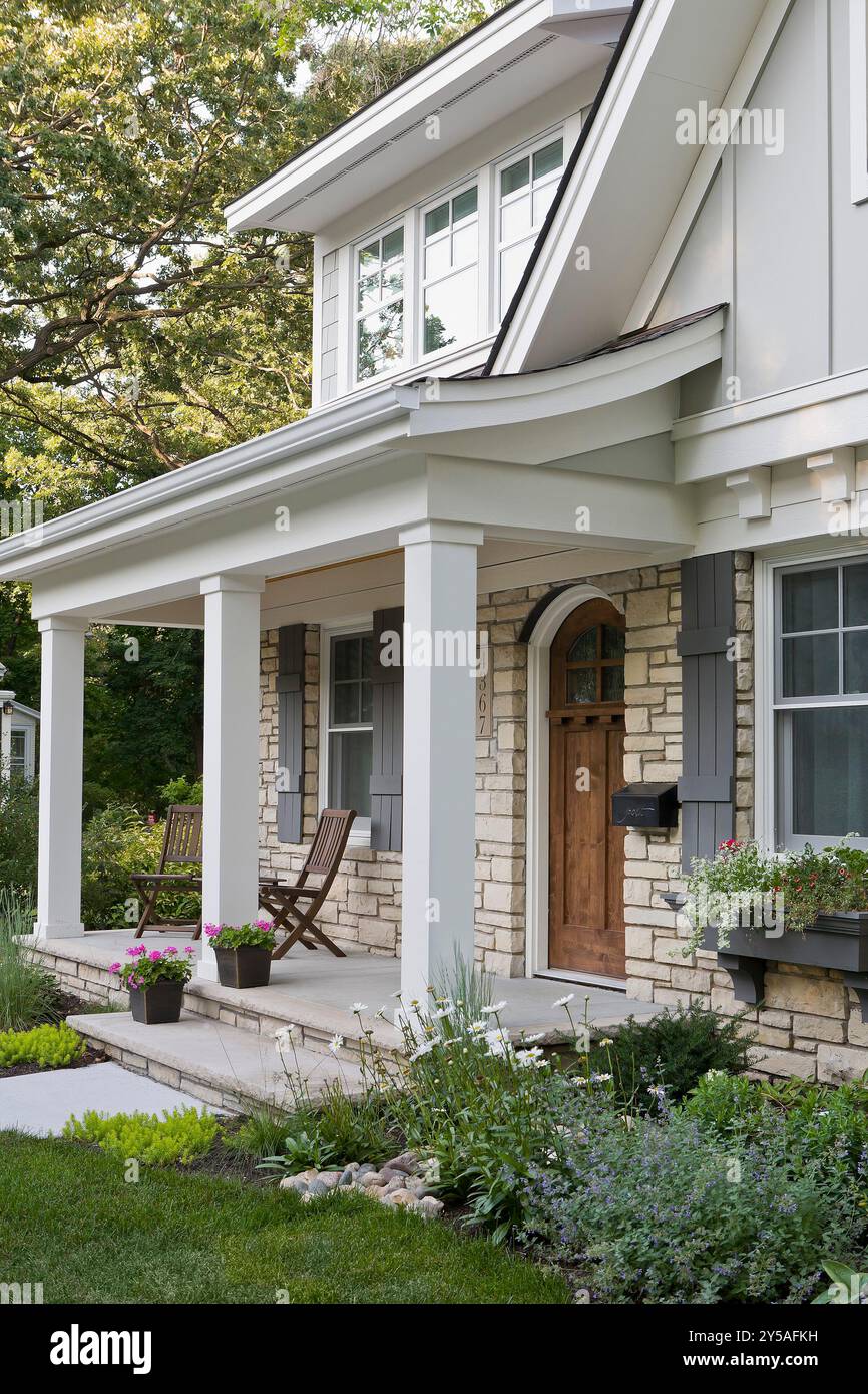 Pretty front porch of house surrounded by flowers and greenery Stock ...