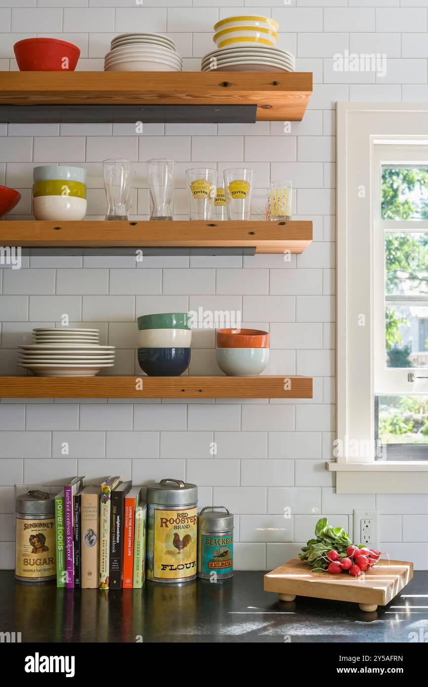Open kitchen shelves with colorful dishes and items on counter Stock ...