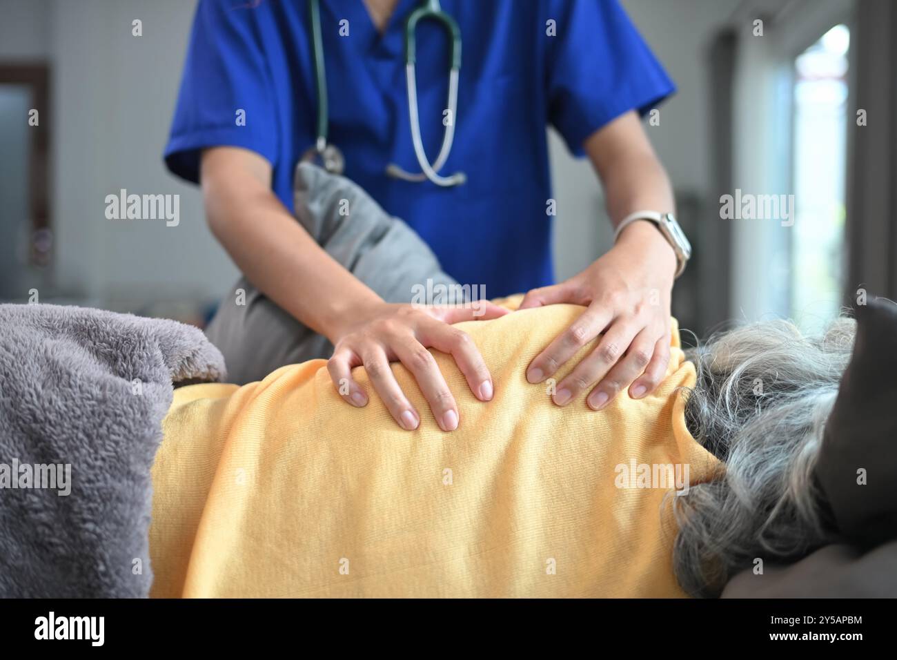 Physiotherapist massaging back muscles in area of shoulder blade of ...