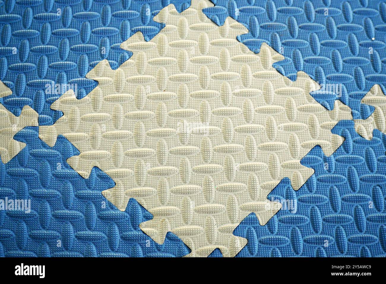 Close-up photo of interlocking blue and white puzzle mats. The mattress ...