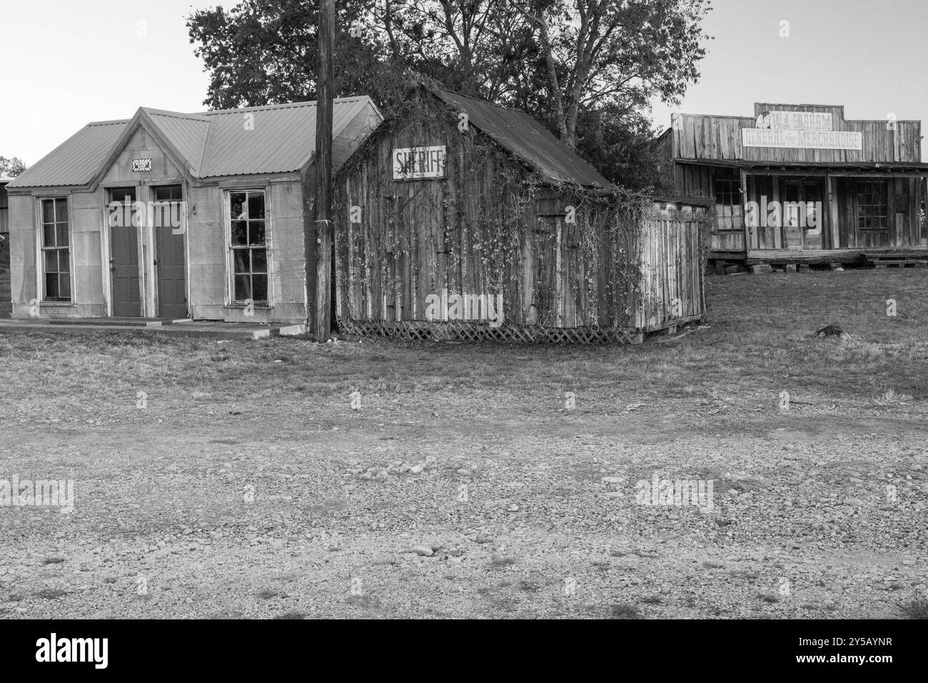 A group of weathered, abandoned wooden historic buildings, one of which ...