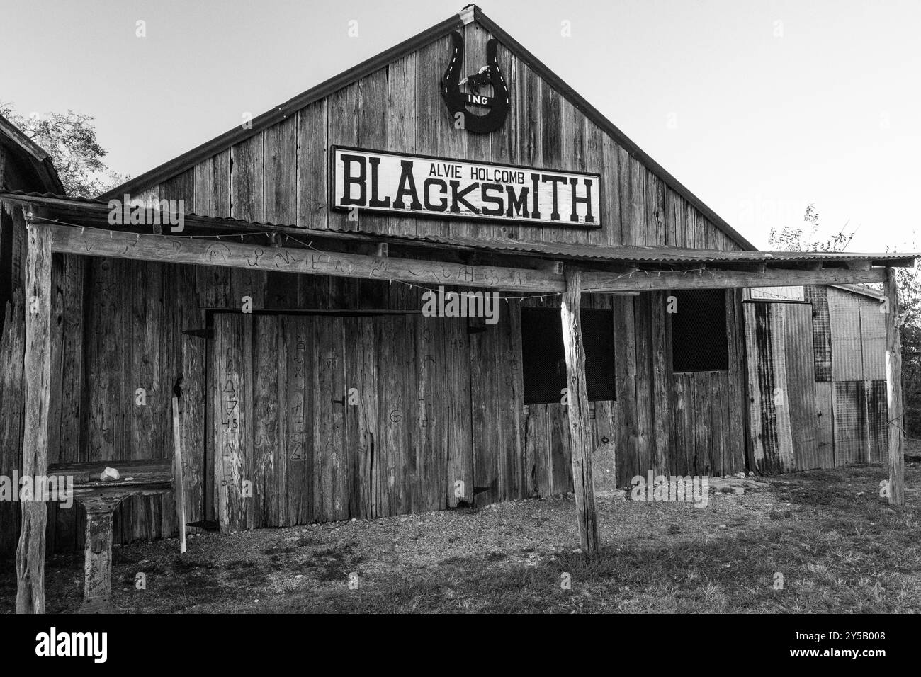 A rustic historic wooden building labeled "Blacksmith". The old sign ...