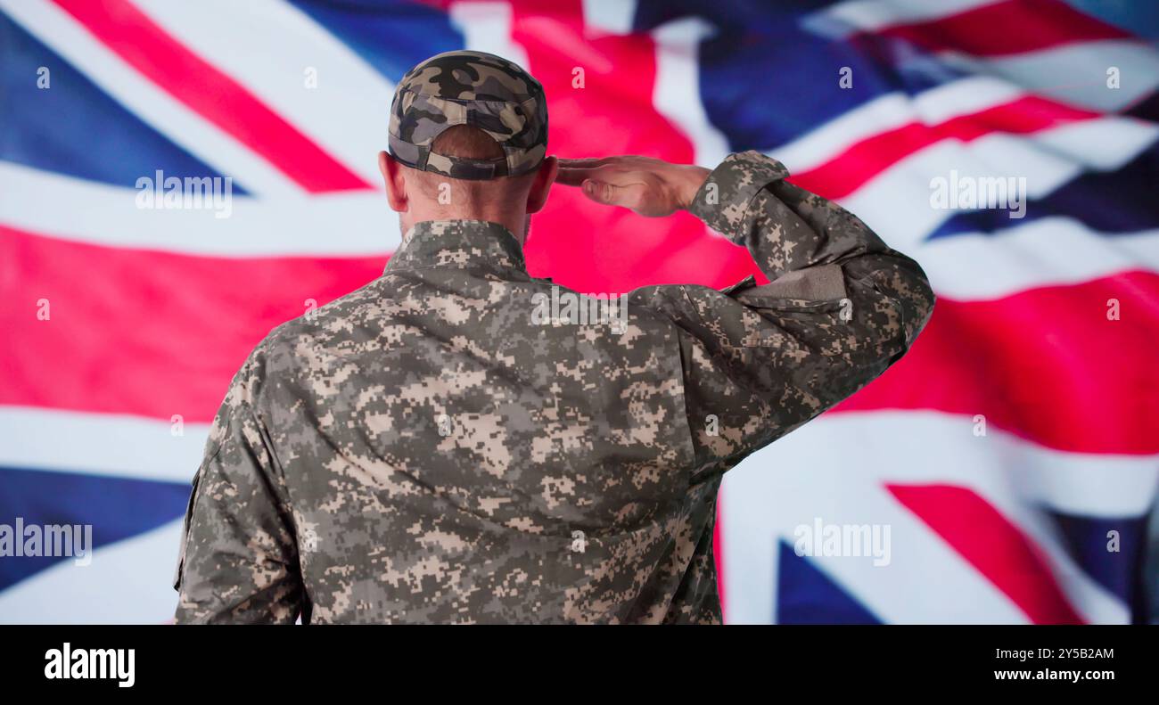 Solider Saluting In Front Of The British Flag Stock Photo - Alamy