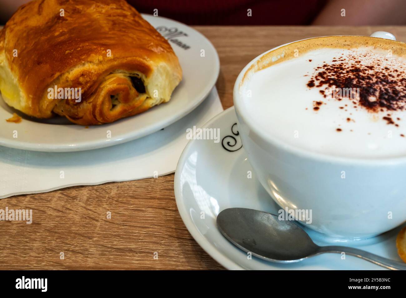 (chocolate croissant (pain au chocolat) and cappuccino on a plate in a ...