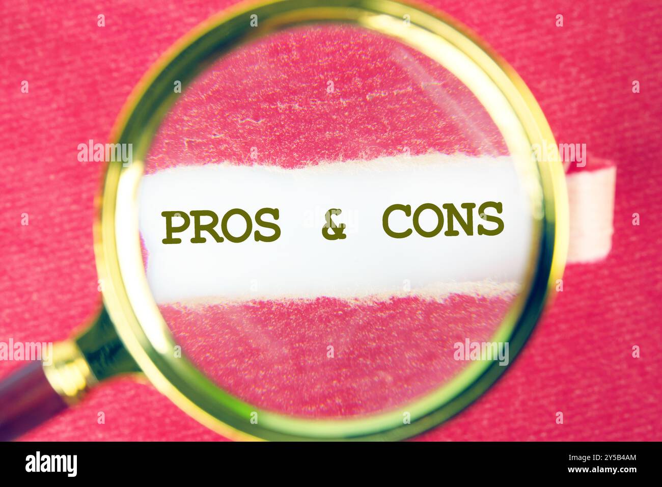 PROS and CONS message on white paper through a magnifying glass under a ...