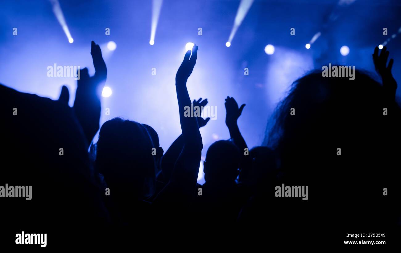 Concert hall full of music fans with hands up during live performance ...