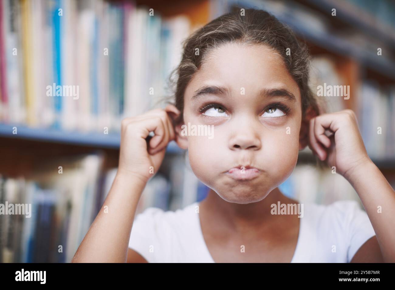 Girl, kid and funny face in pulling ears at school library on break for ...