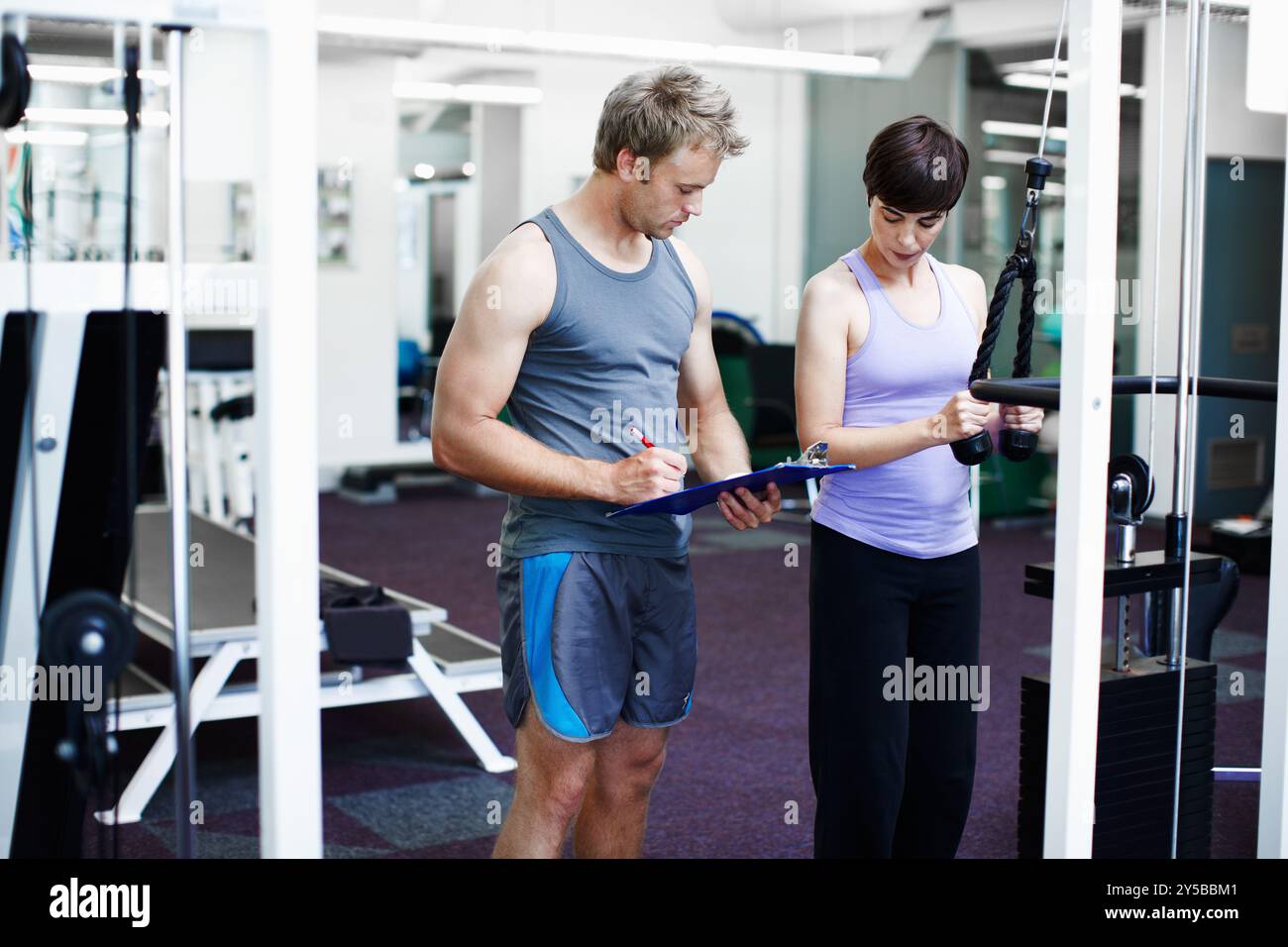 Coach, woman and clipboard with weightlifting machine, assessment and ...