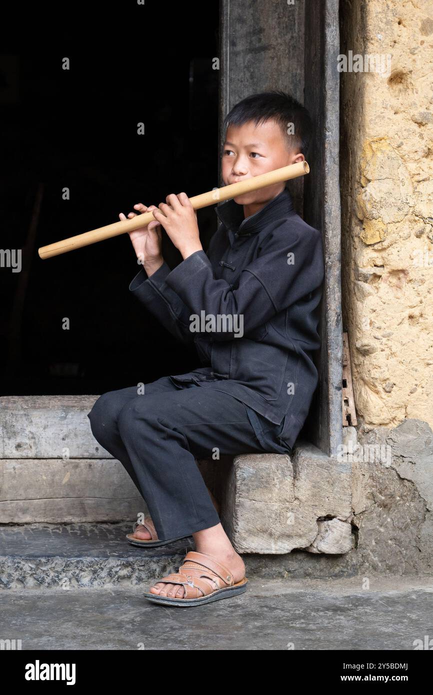 Young Hmong boy playing the flute at the Lung Cam Cultural Village in ...
