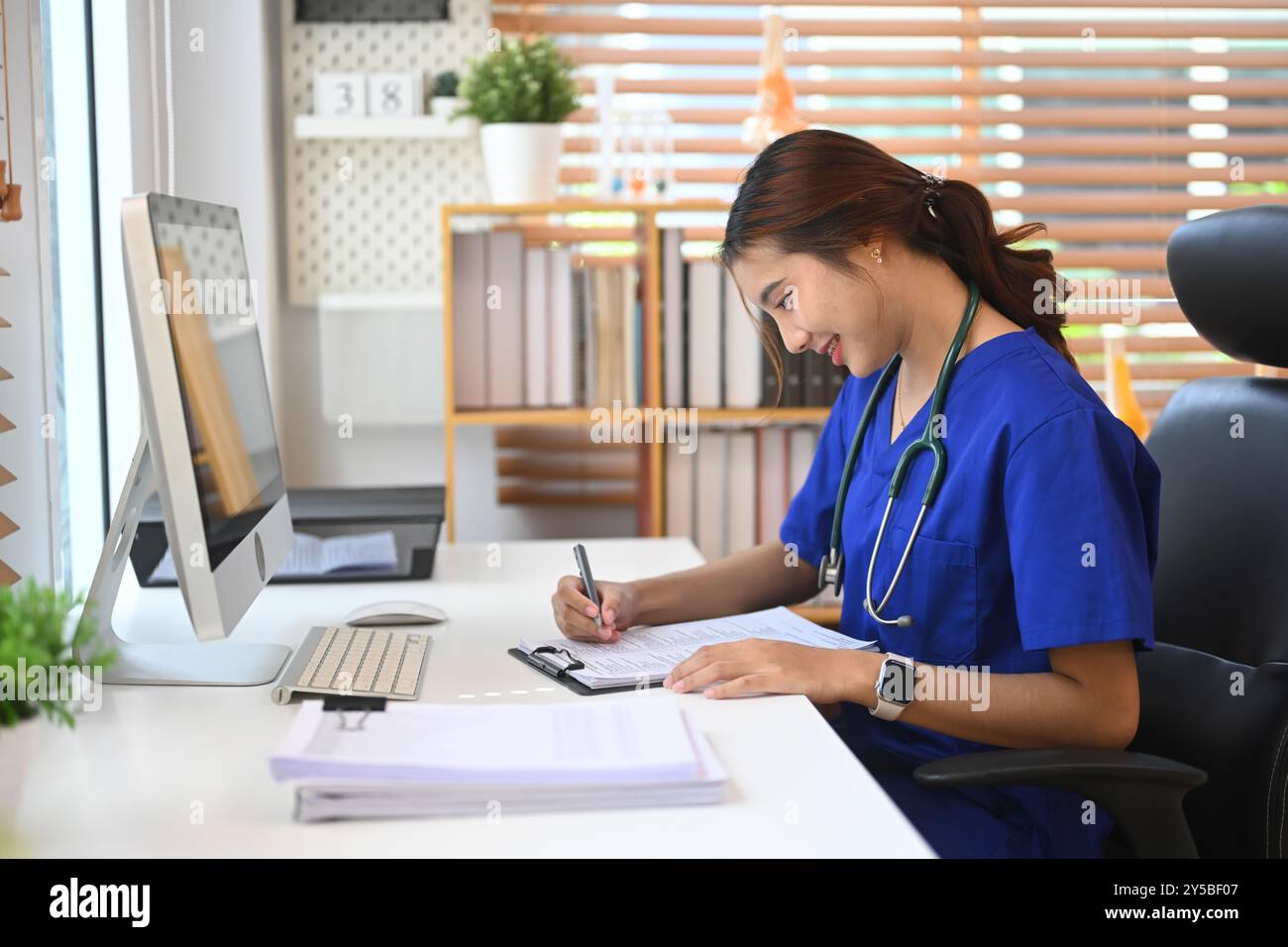 Doctor nurse reviewing blue folder hi-res stock photography and images ...