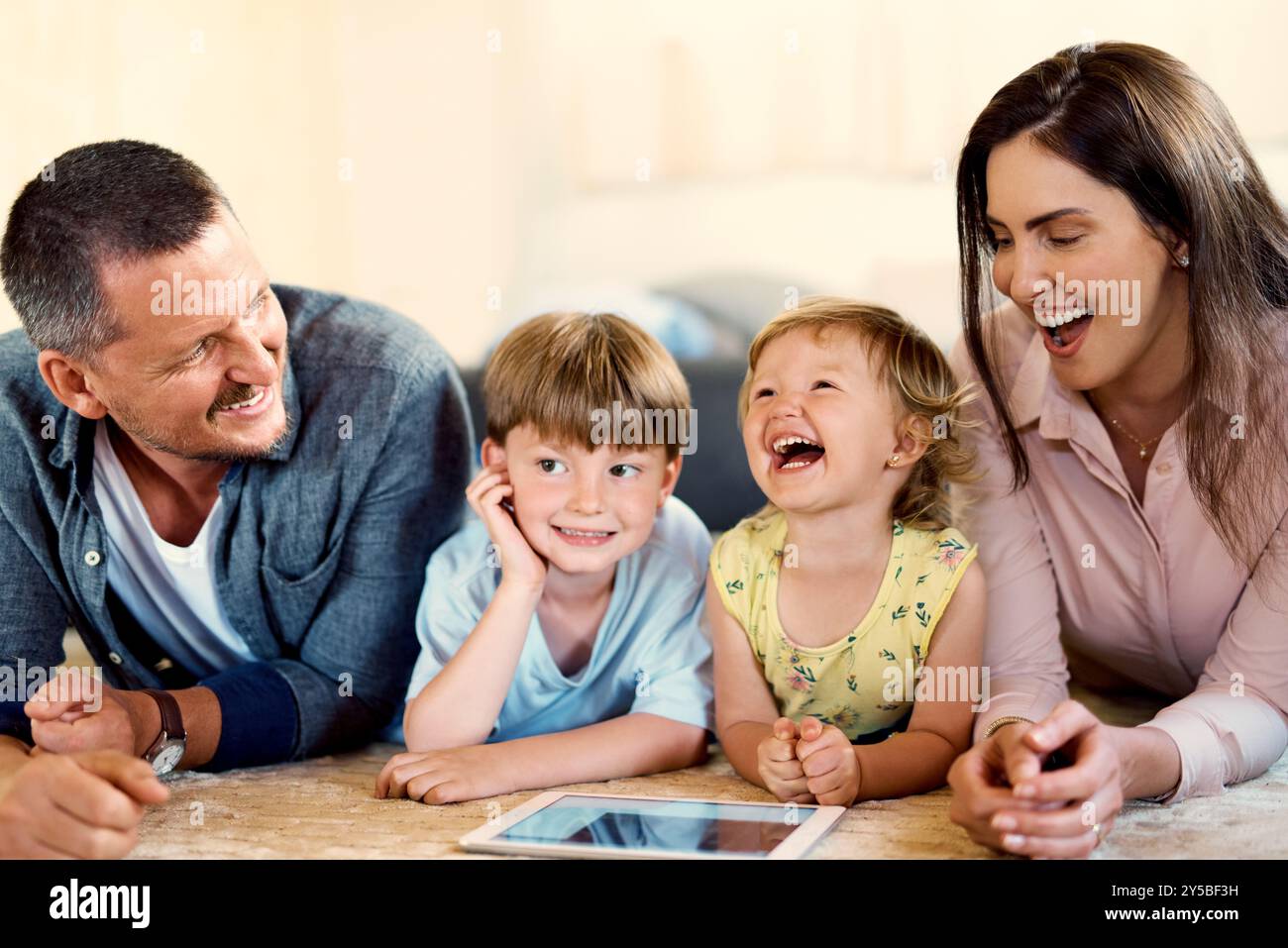 Family, tablet and watching comedy in home, funny movies and laughing ...