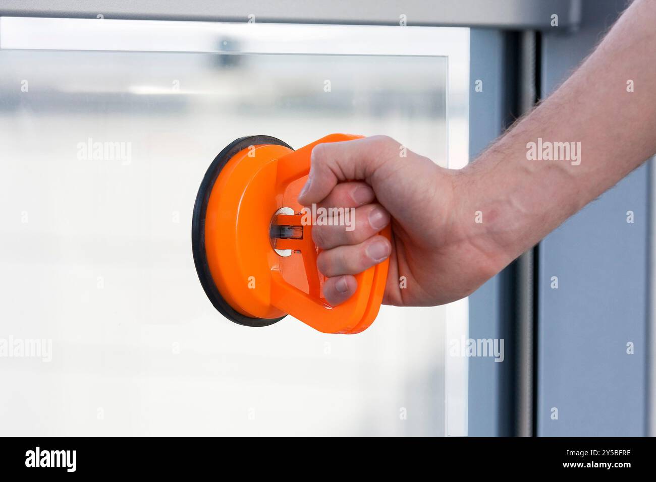 Window with orange suction cup hold in the hand Stock Photo - Alamy