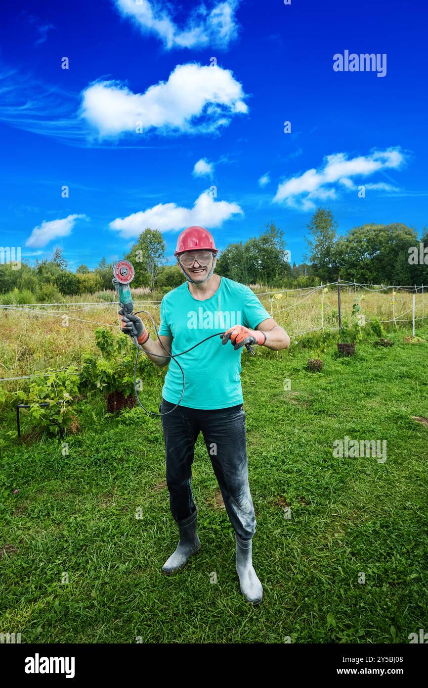 Angle grinder with diamond wheel in hands of smiling man in protective ...