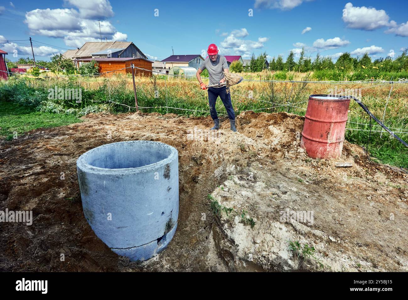 Builder buries concrete septic tank rings during installation sewer ...