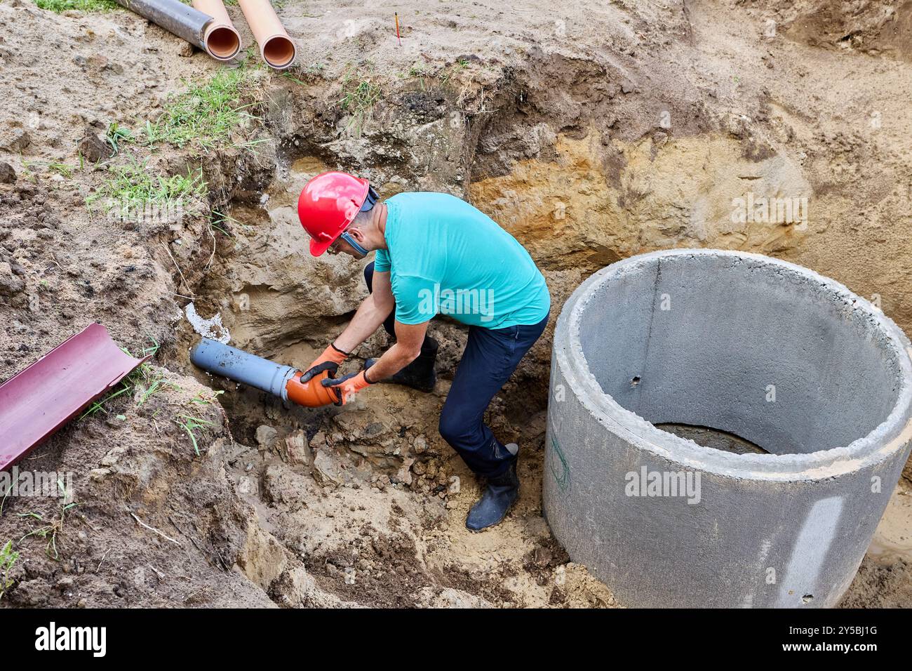 Installing plastic drain underground pipe, gravity drainage, plumber ...