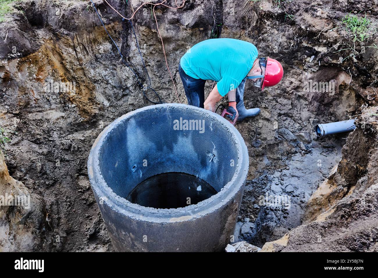 Using hammer drill with chisel, worker made hole in concrete ring of ...