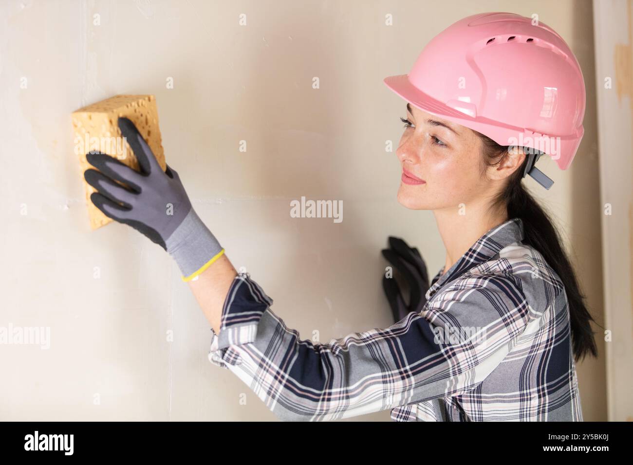 female builder using sponge on wall Stock Photo - Alamy