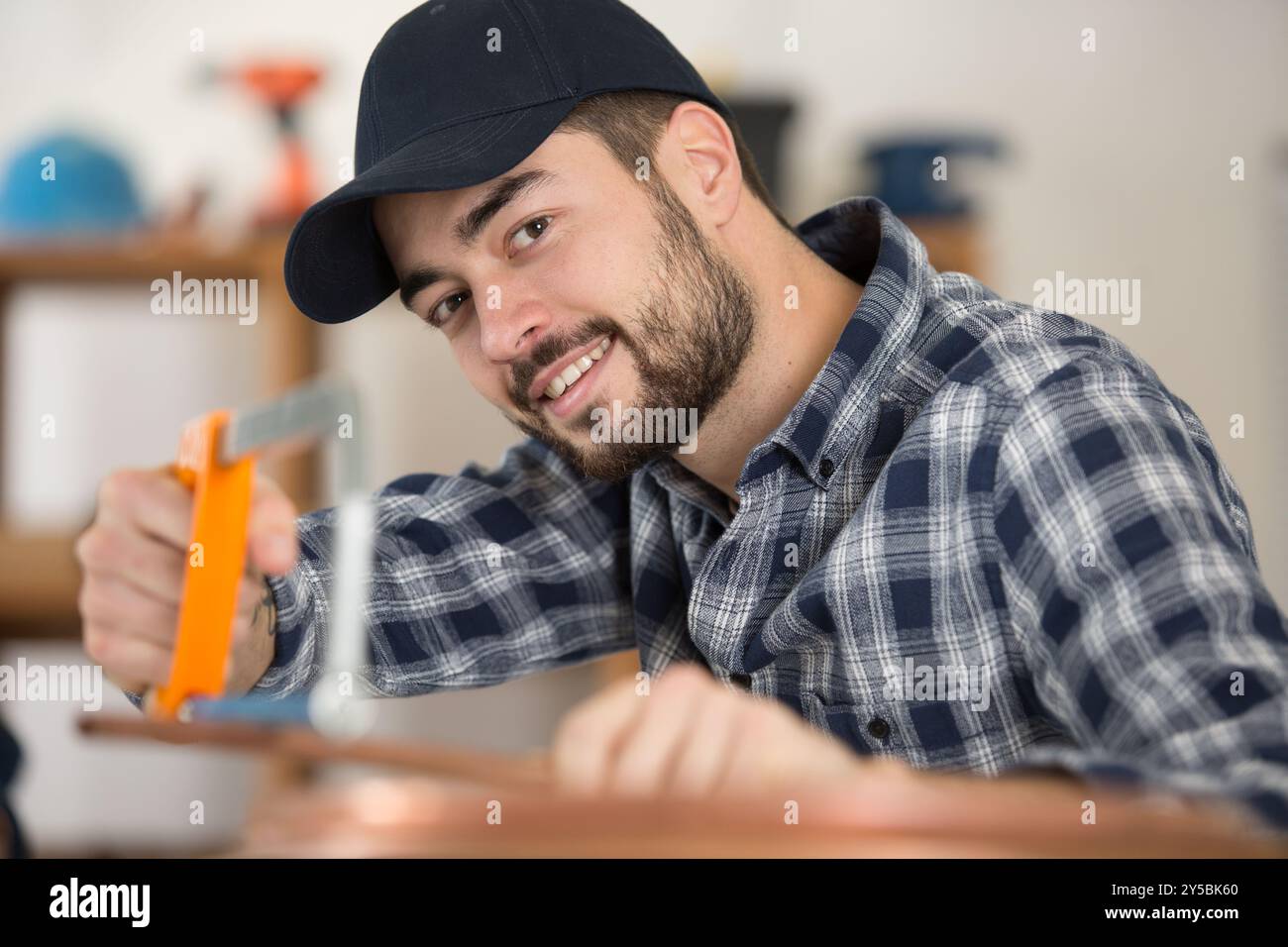 tradesman cutting copper pipe with hacksaw Stock Photo - Alamy