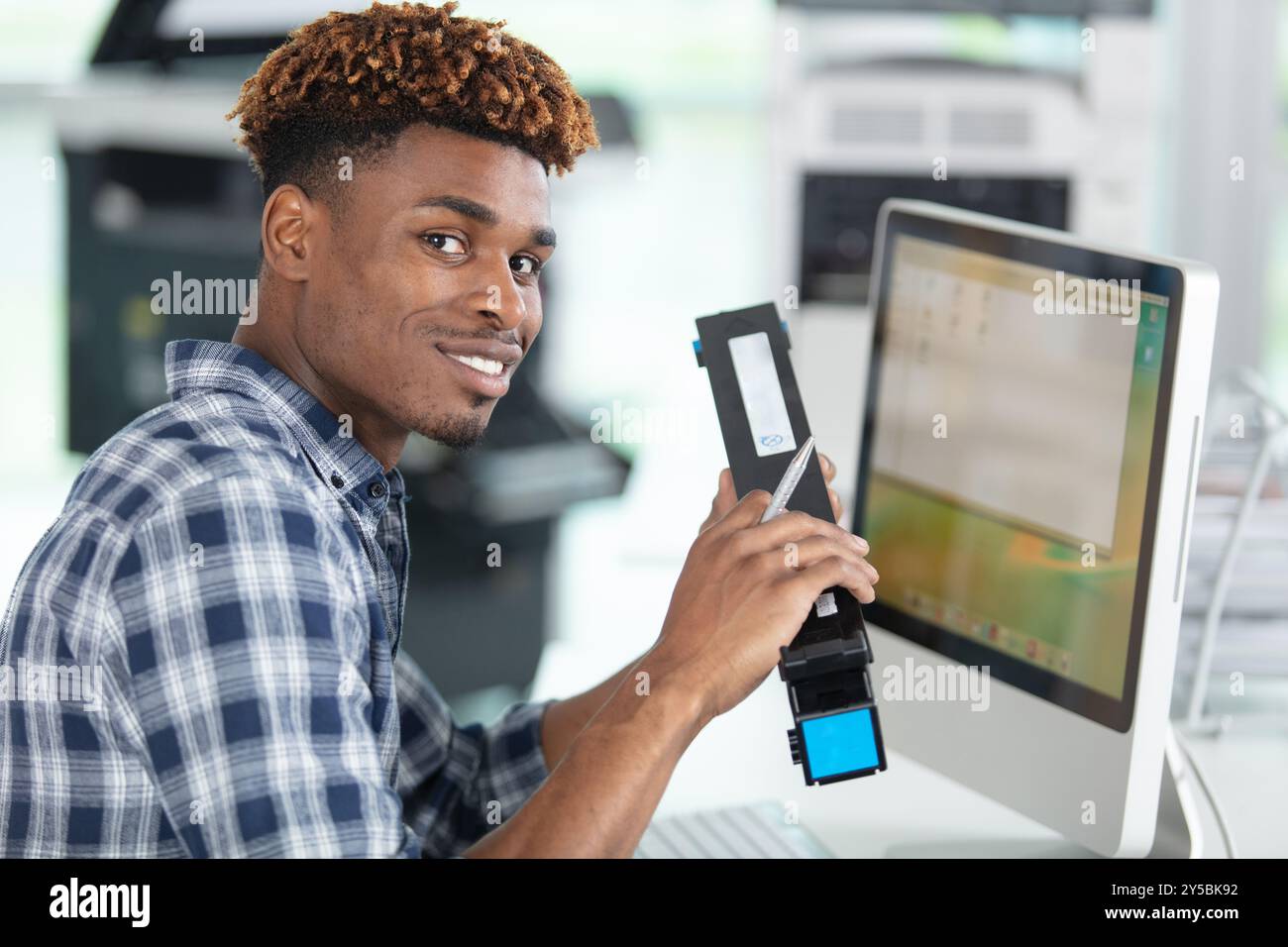 handsome unsmiling computer engineer working at open computer Stock ...