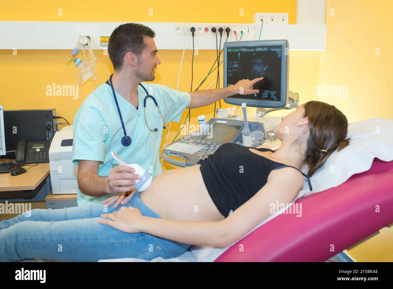 octor moving ultrasound probe on pregnant womans stomach in hospital ...
