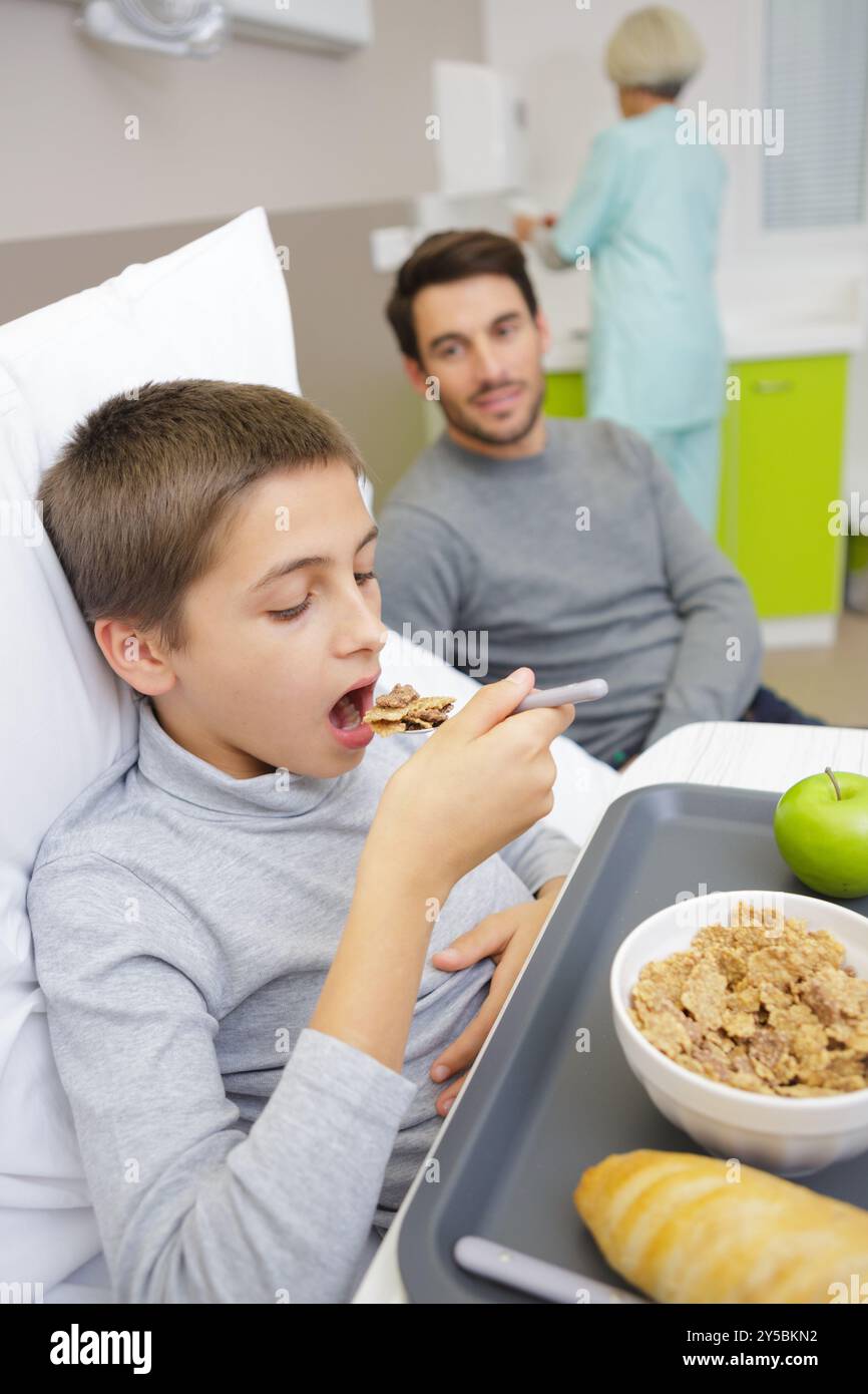 sick little boy eating hospital food Stock Photo - Alamy