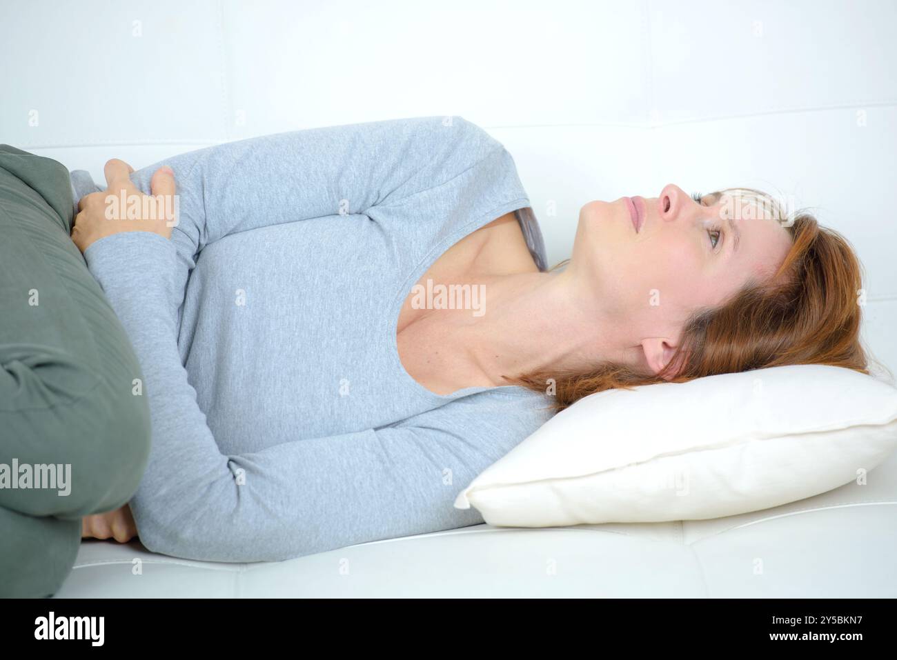woman curled up on sofa Stock Photo - Alamy