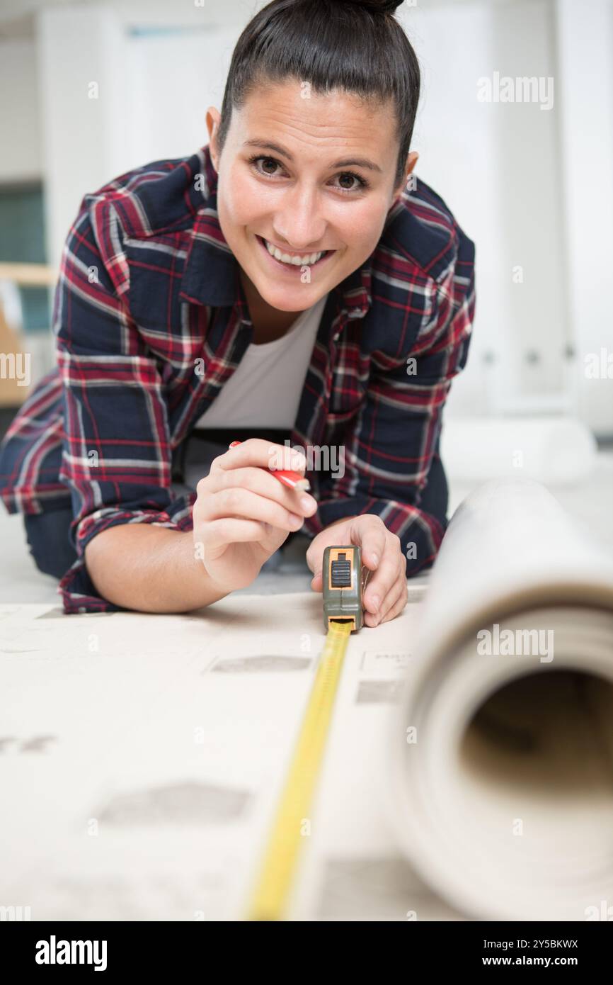 happy female worker measuring a piece of carpet Stock Photo - Alamy