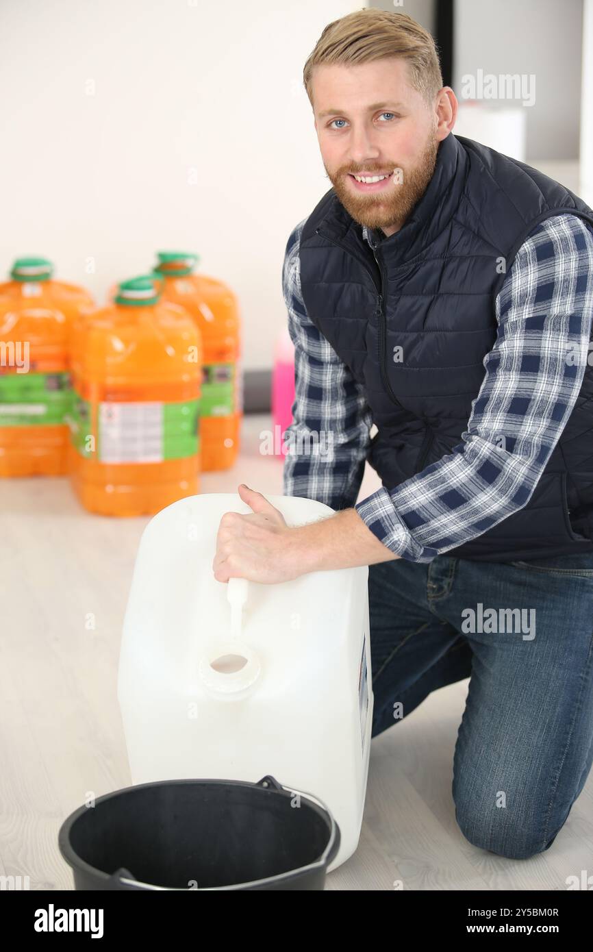 man pouring industrial chemical into bucket Stock Photo - Alamy