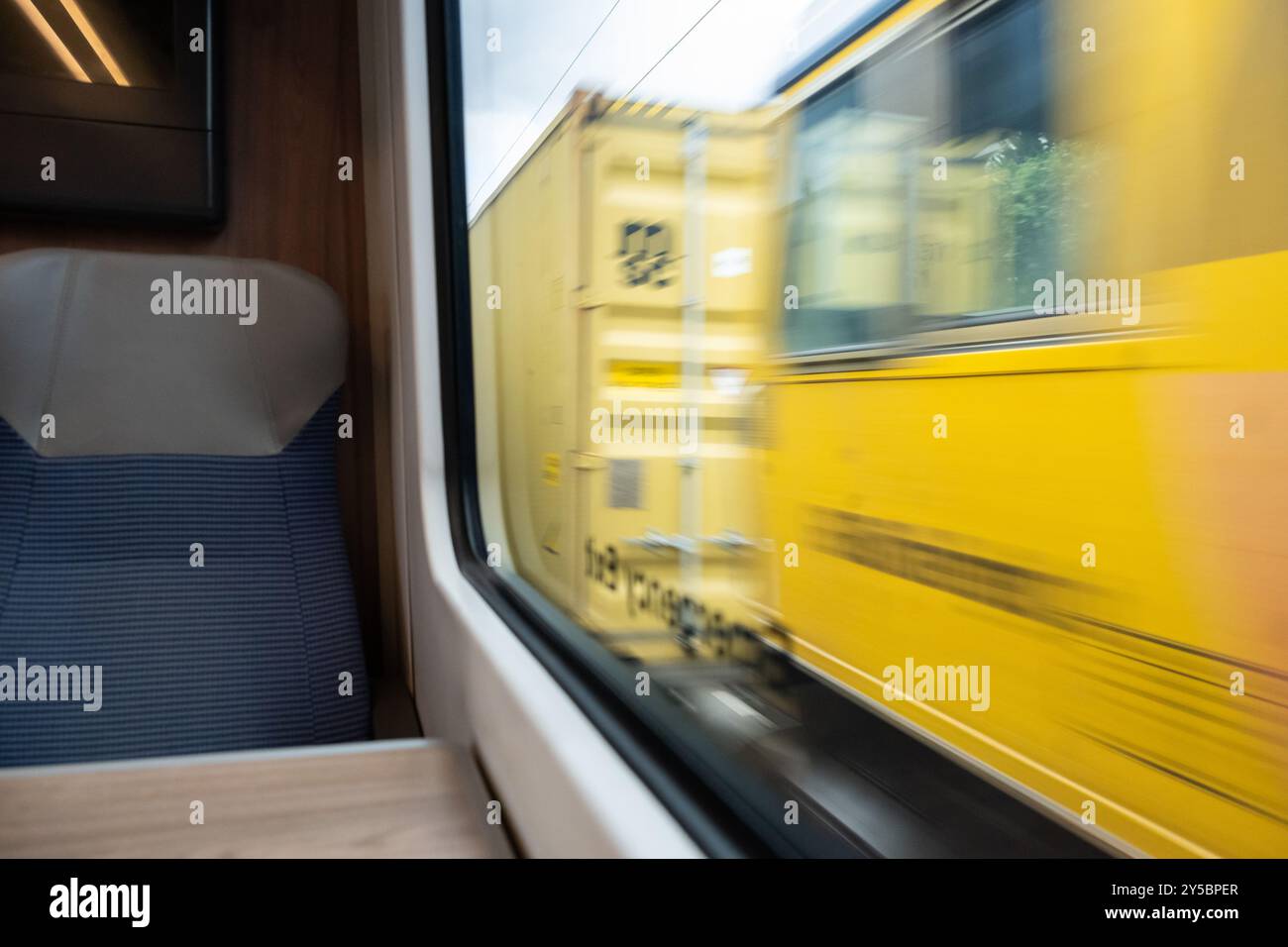 A freight train passing a passenger train as seen through passenger ...