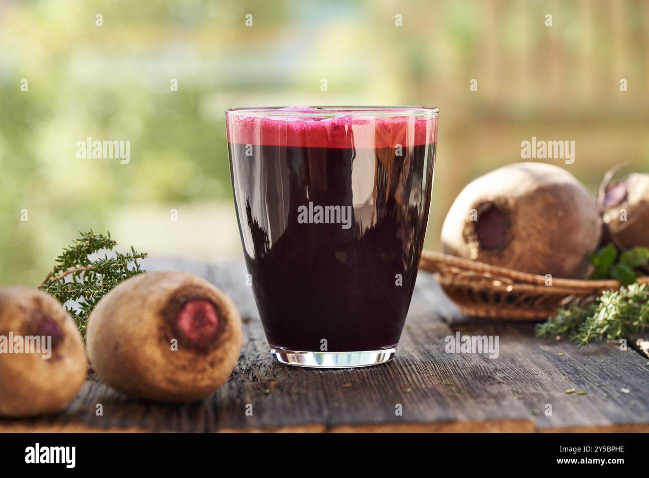 Red beet juice in a glass cup with fresh whole beetroot outdoors Stock ...