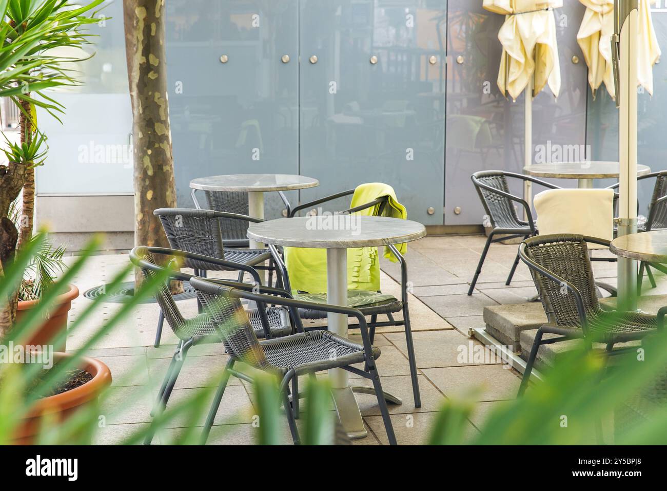 Outdoor cafe seating with empty tables and chairs in an urban street ...