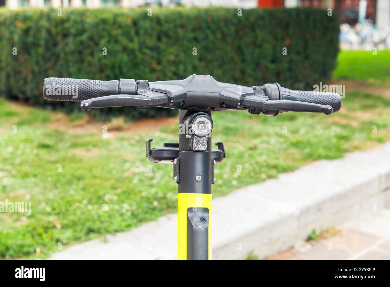Close-up view of handlebars of modern electric scooter parked outdoors ...