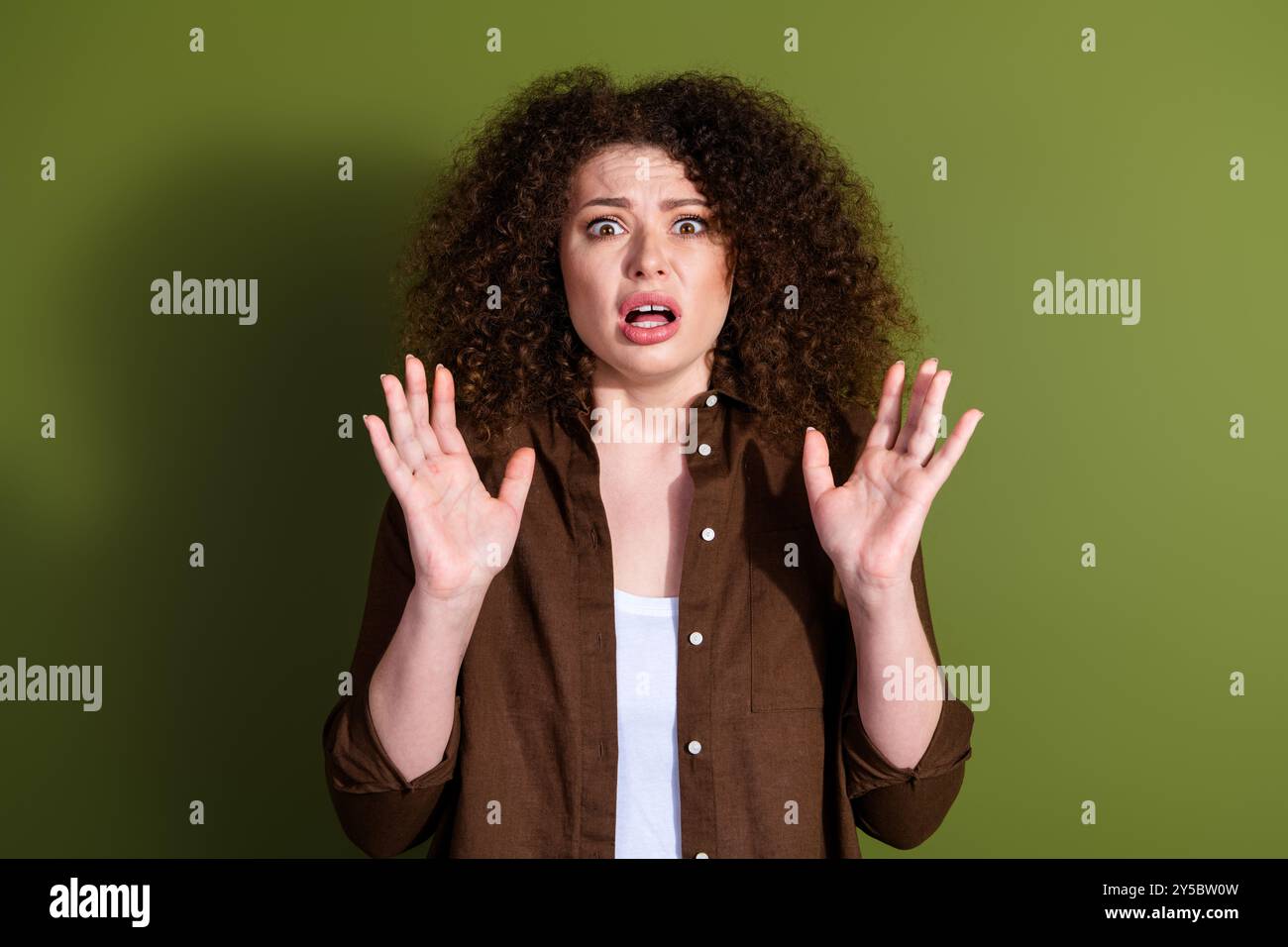 Photo of pretty young woman raise arms scared face wear brown shirt ...