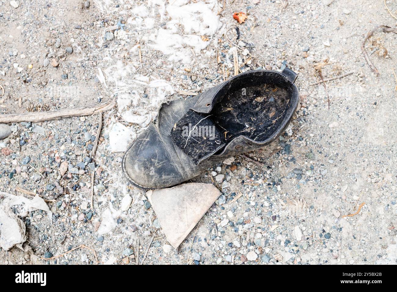 top view of old torn discarded forgotten men's shoe on broken concrete ...