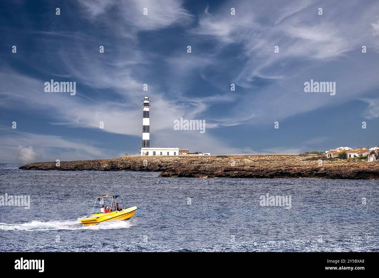 Speed boat approaching Artrutx lighthouse in Cala n'bosch, Menorca ...