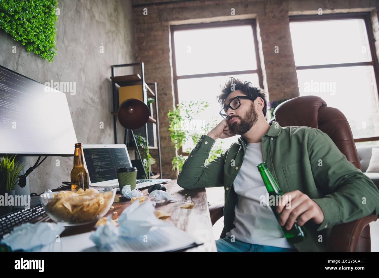 Portrait of professional hacker young man beer bottle chips computer ...