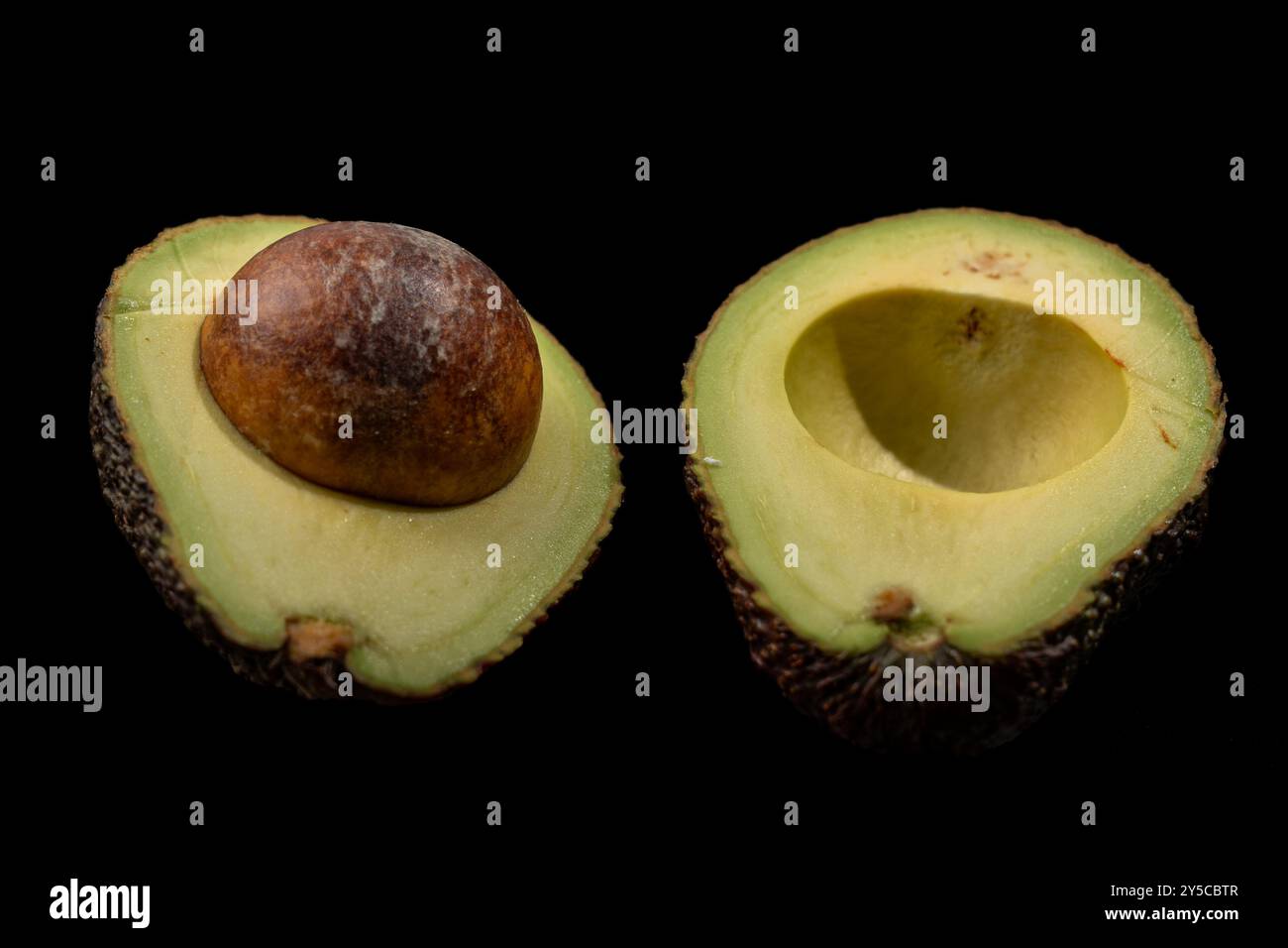 Two avocados are cut in half, revealing their green insides. Concept of ...