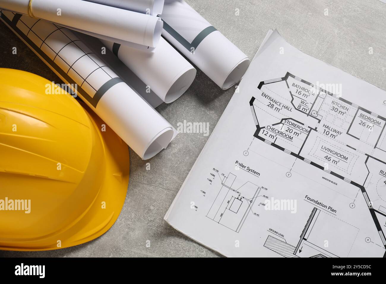 Different engineering drawings and hard hat on grey textured table ...