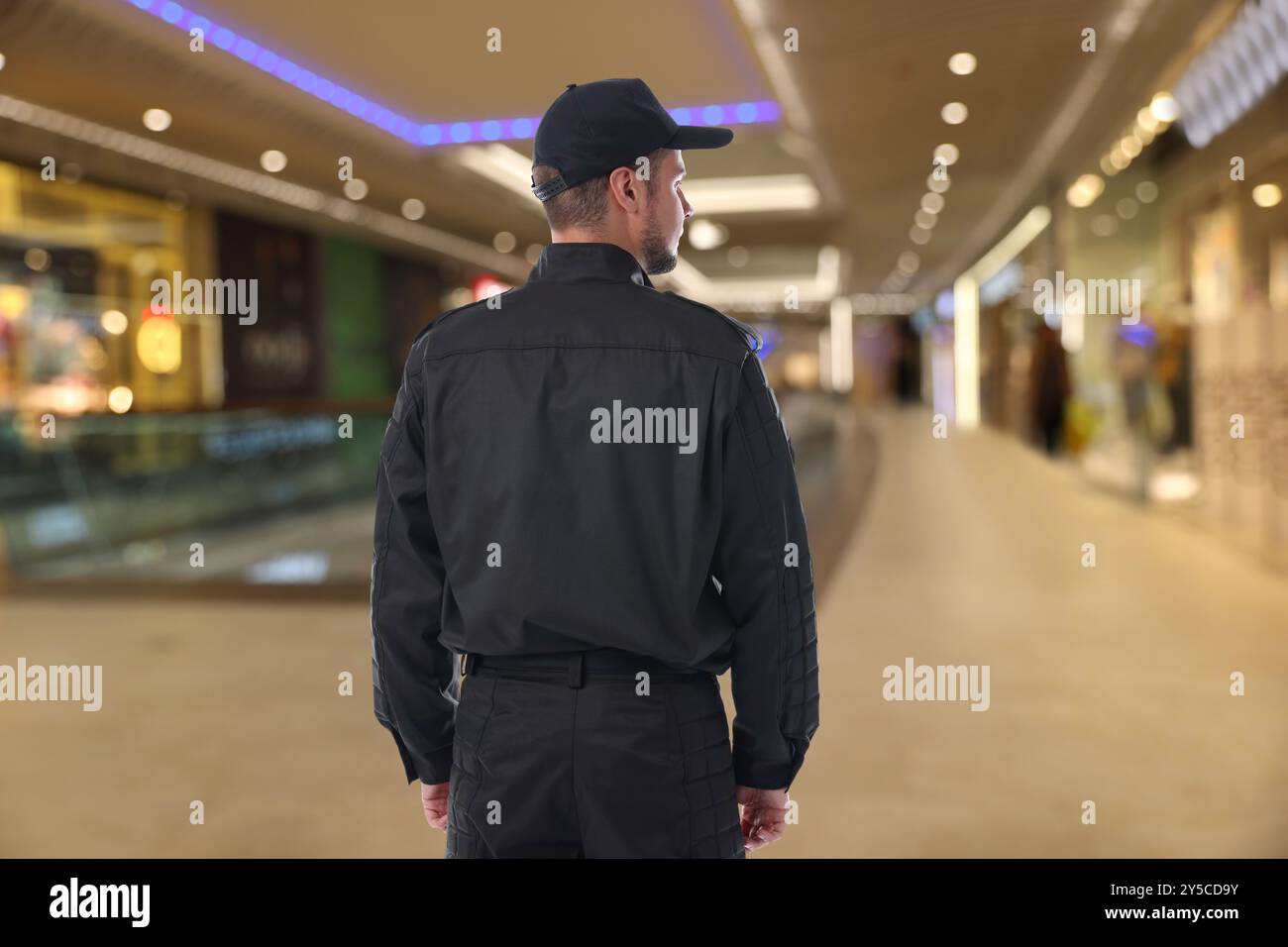 Security guard wearing uniform in shopping mall, back view Stock Photo ...