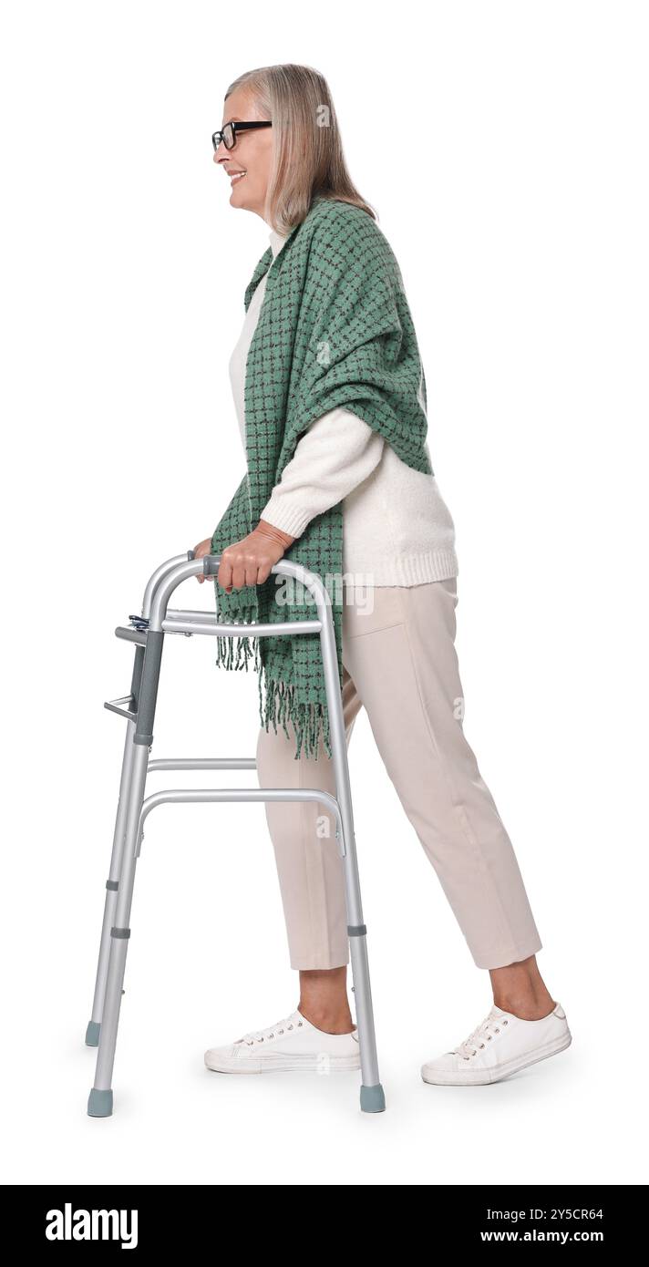 Senior woman using walking frame on white background Stock Photo - Alamy