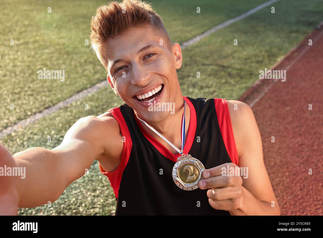 Happy winner with silver medal taking selfie at stadium Stock Photo - Alamy