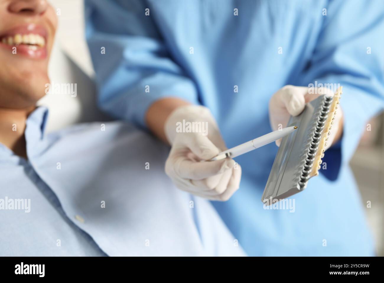 Doctor and patient choosing shade on teeth color palette in clinic ...