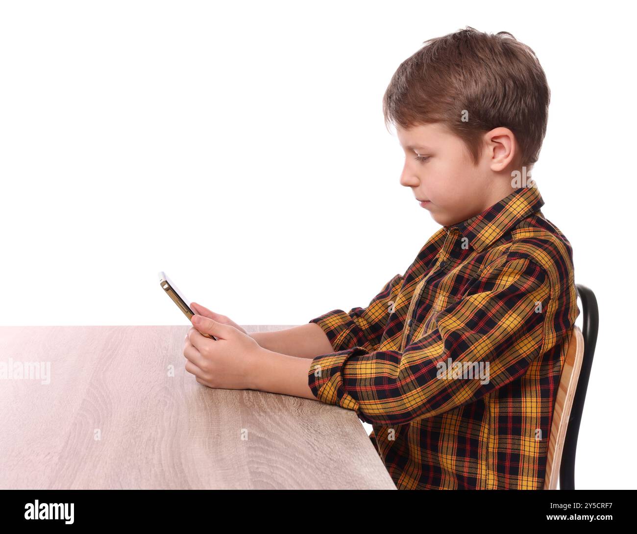 Boy with correct posture and phone at wooden desk on white background ...