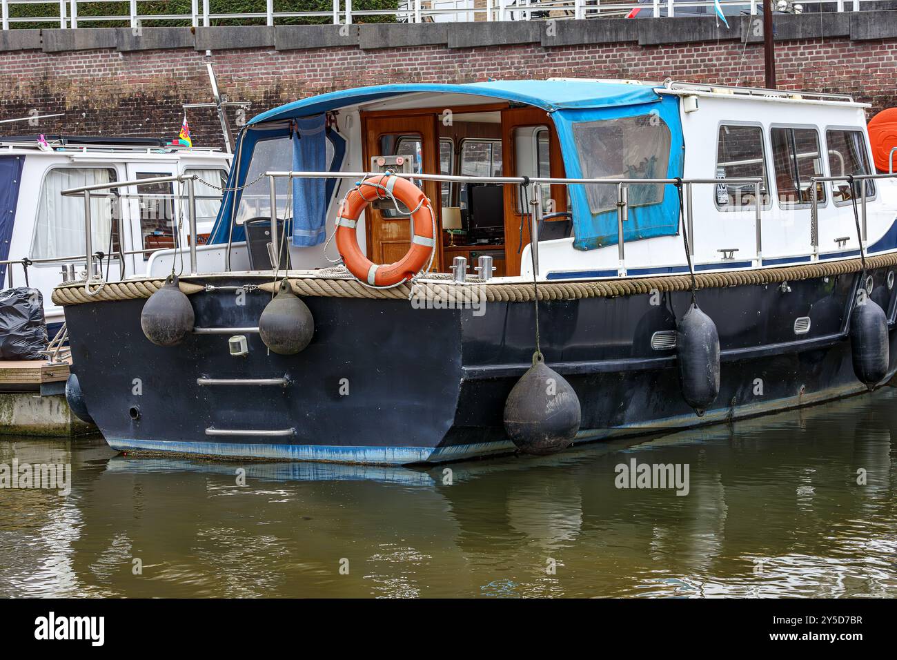 Stern of a ship with buoys hanging moored at quayside of old historic ...