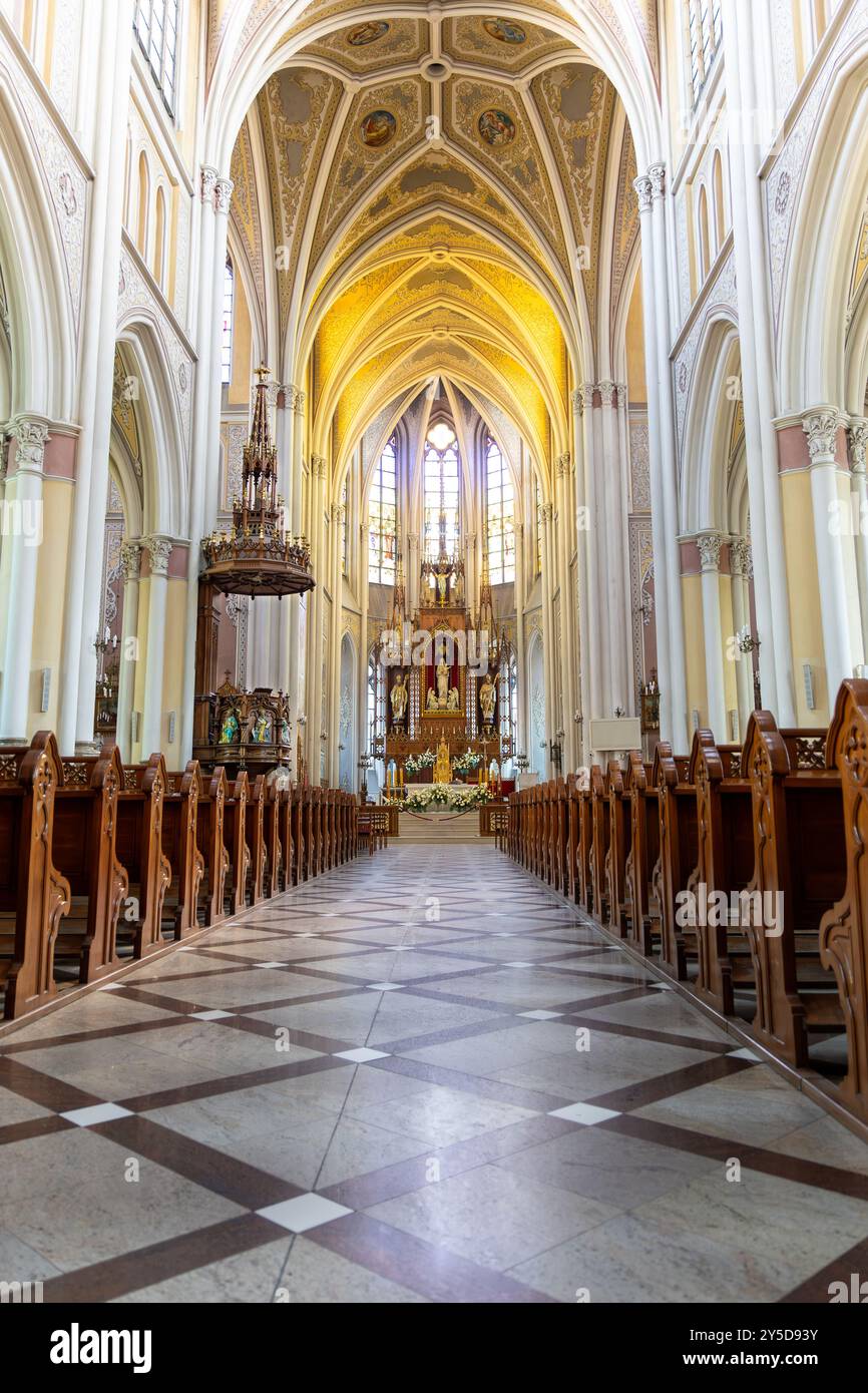 A majestic view of the Gothic cathedral’s interior featuring a long ...