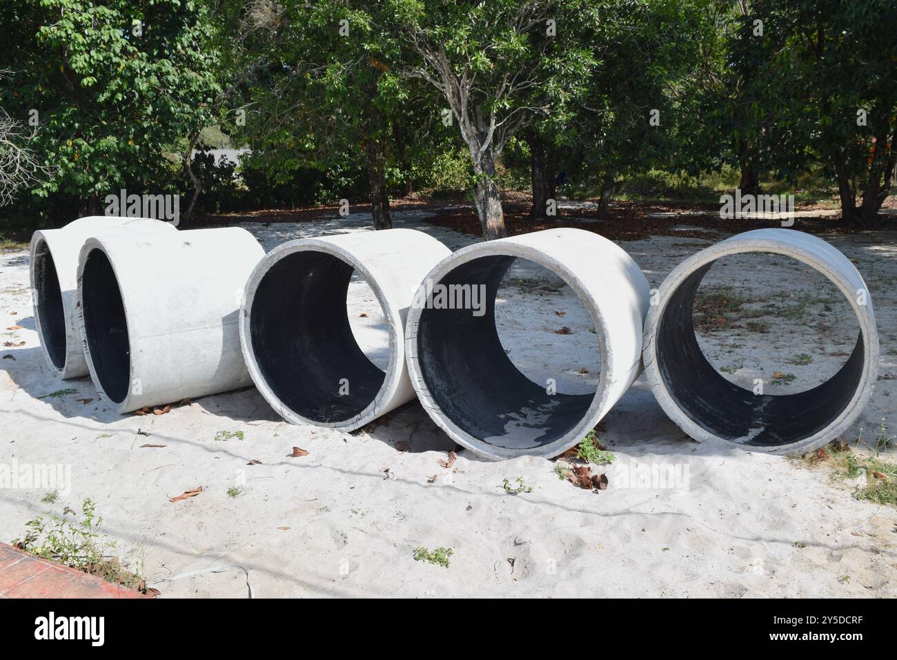 Cement round pipes on sandy beach Stock Photo - Alamy