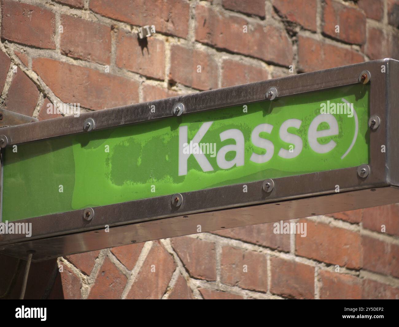 Green checkout sign on a red brick wall Stock Photo - Alamy