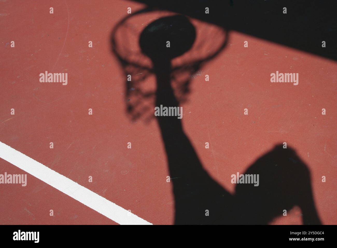 A Shadow Basketball player dunking on red court Stock Photo - Alamy