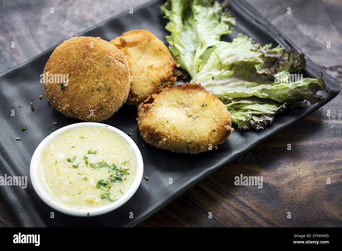 Fried fish cakes with creamy garlic butter sauce snack Stock Photo - Alamy