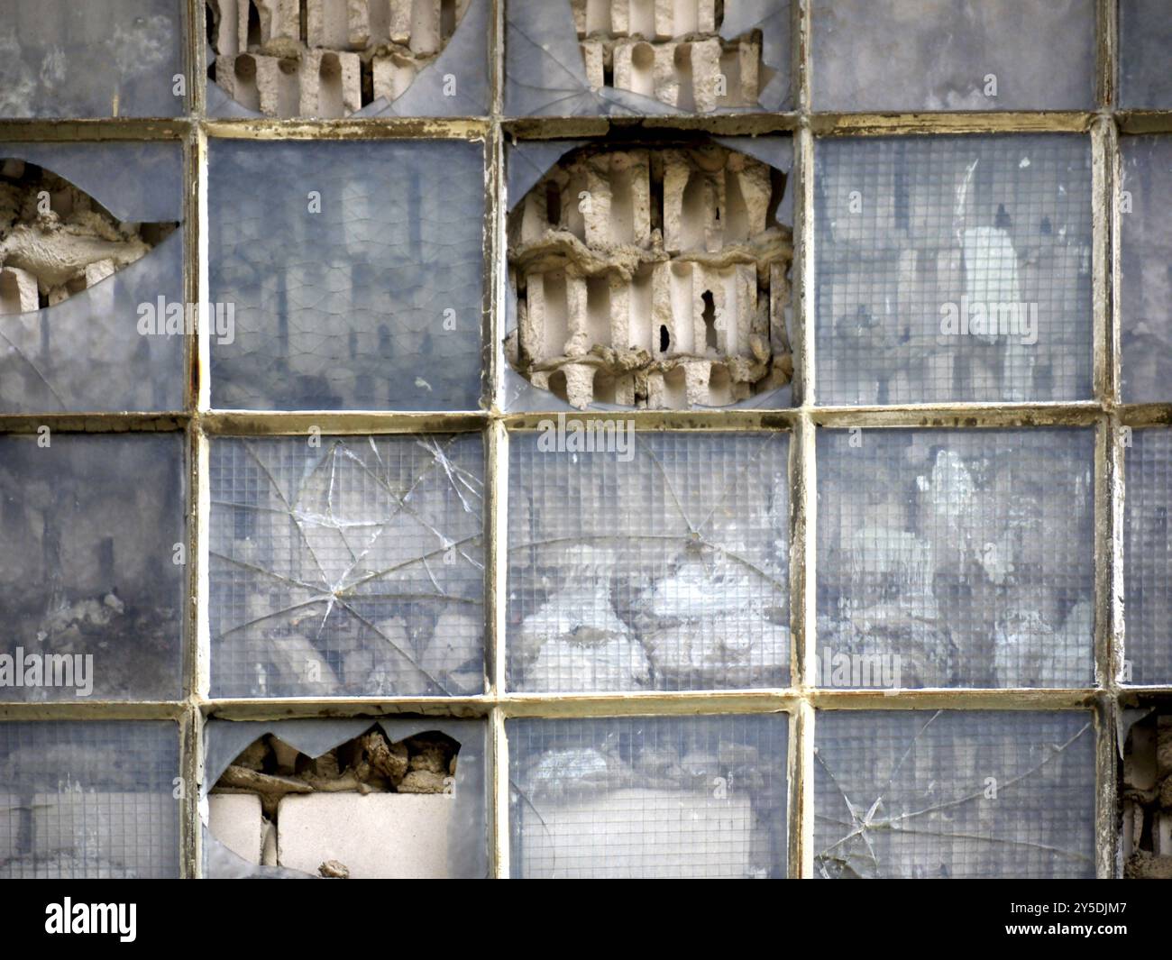 Wall behind small broken glass windows Stock Photo - Alamy
